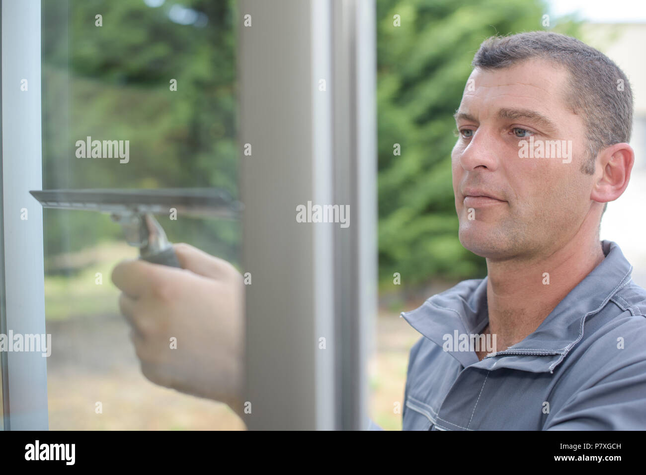 Man wiping window with squeegee Stock Photo - Alamy