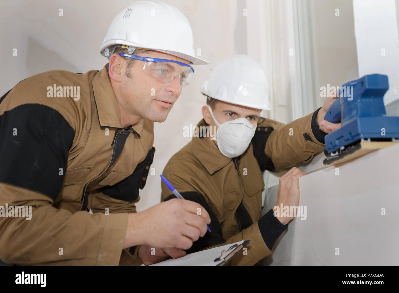 male construction workers smoothing wall surface Stock Photo - Alamy