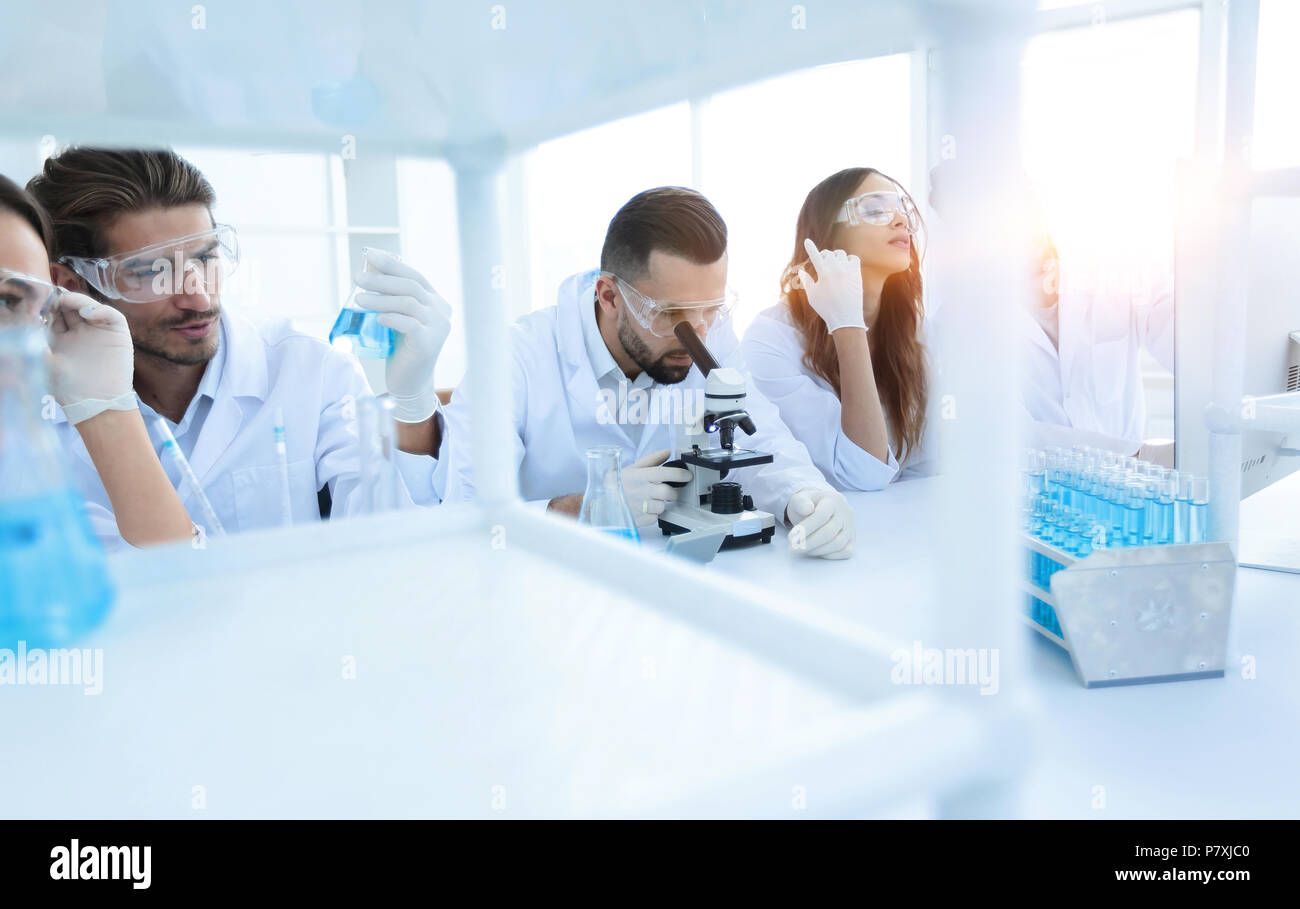 background image is a group of scientists working in the laboratory ...