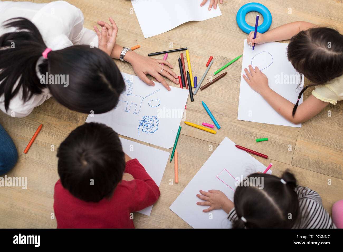 Group of preschool student and teacher drawing on paper in art class ...