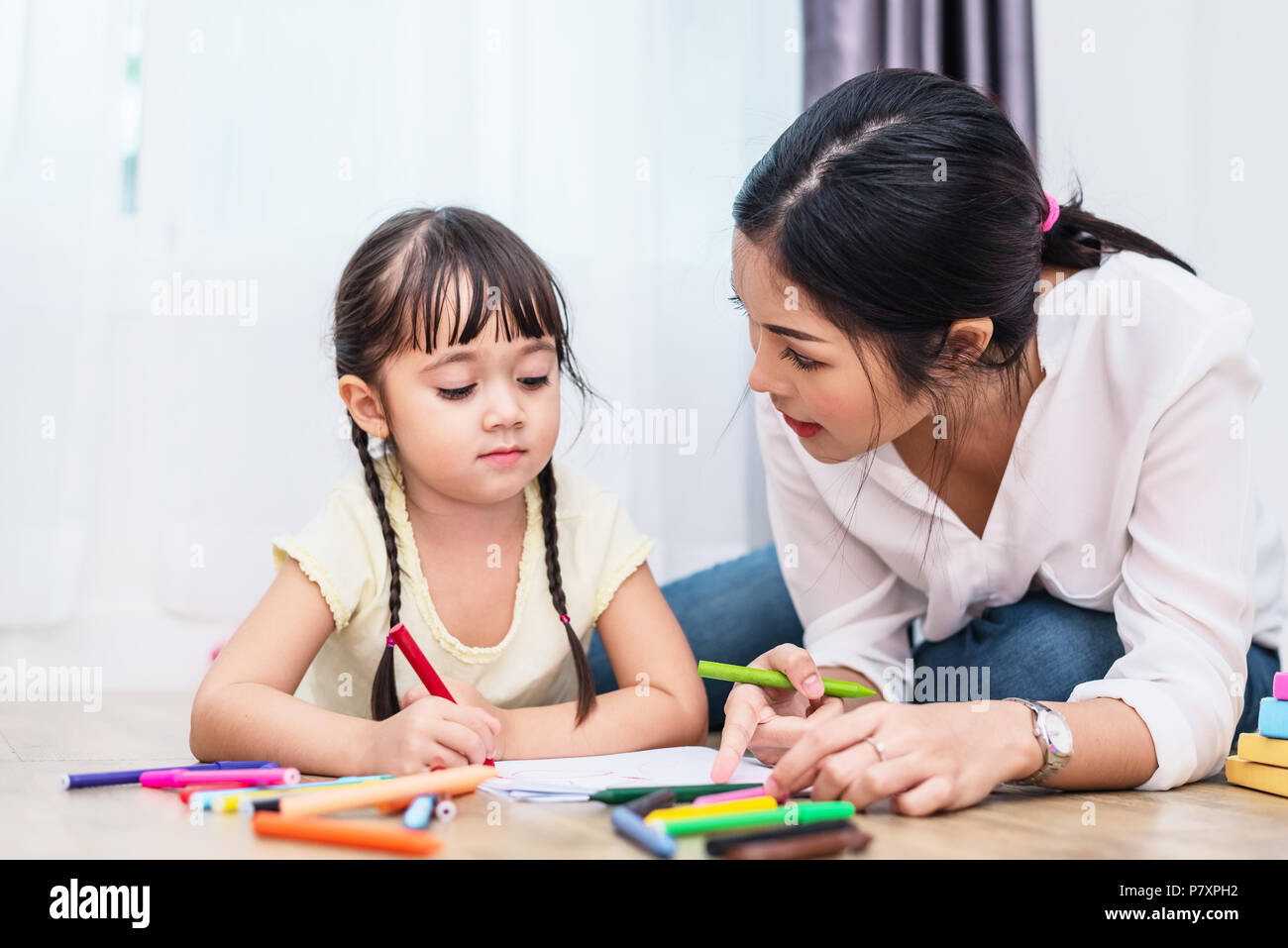 Mom teaching her daughter to drawing in art class. Back to school and ... Mom teaching her daughter to drawing in art class. Back to school and ...