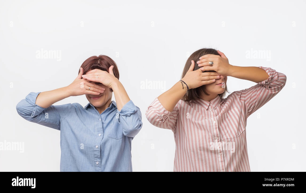 Two european women mother and daughter covering their faces using hands ...