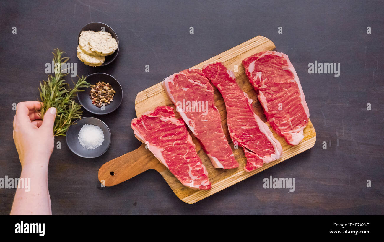 Raw New York strip steaks on a wood cutting board Stock Photo - Alamy