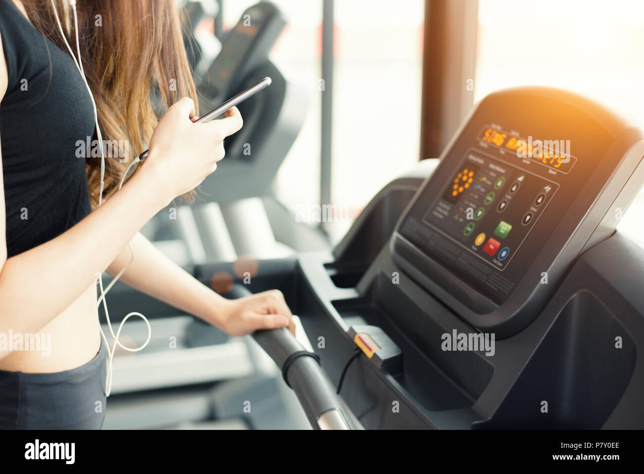 Asian woman using smart phone when workout or strength training at ...