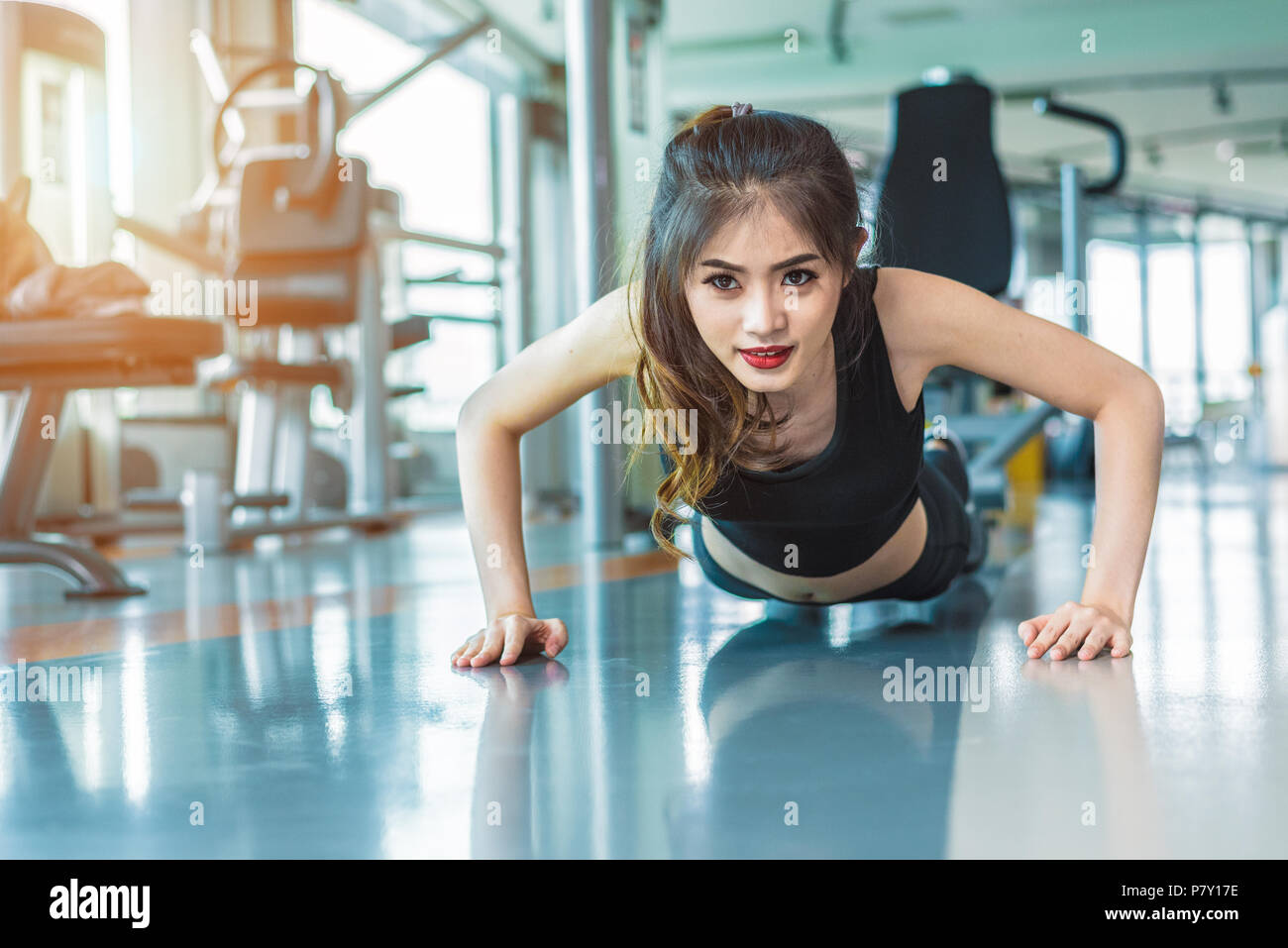 Asian woman fitness girl do pushing ups at fitness gym. Healthcare and ...