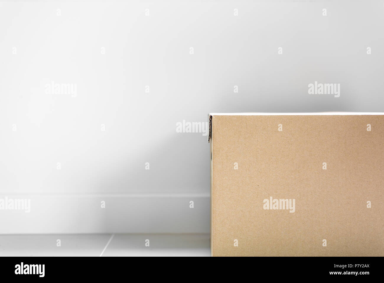 Box package parcel for post delivery on floor with grey wall background ...