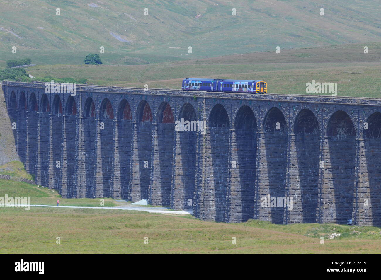 A Northern Rail train crosses over the impressive Ribblehead Viaduct ...