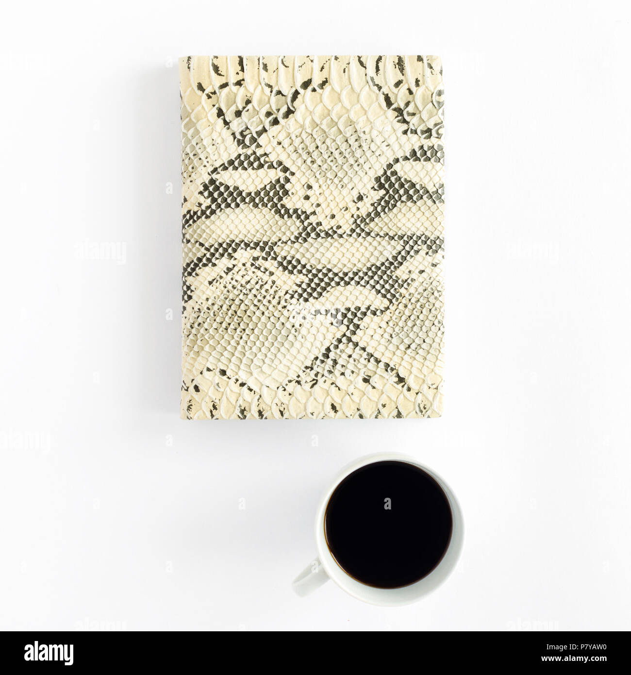 Feminine desk workspace with closed diary and cup coffee on white ...