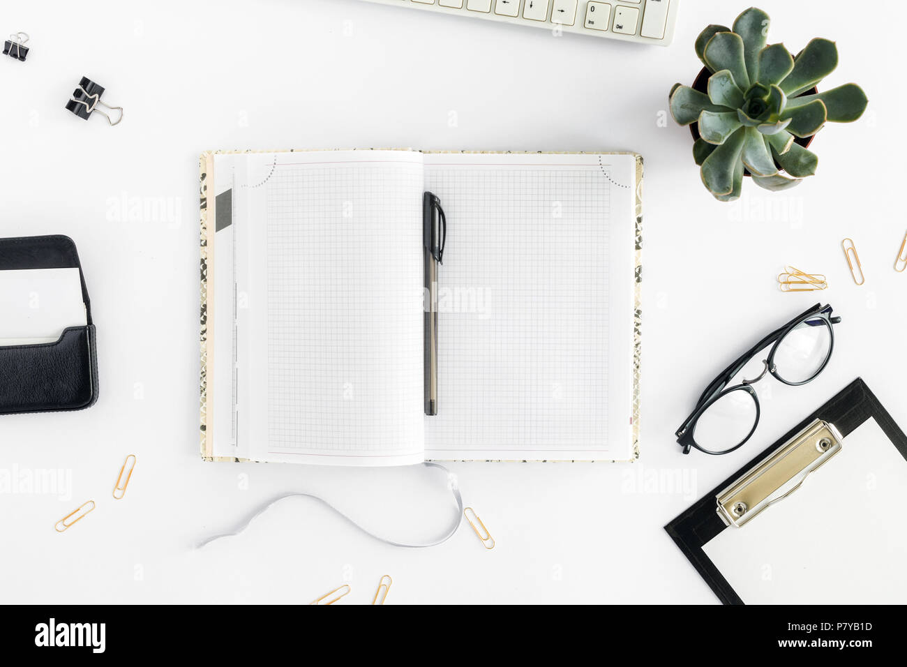Feminine desk workspace with open diary, succulent, clipboard, keyboard ...