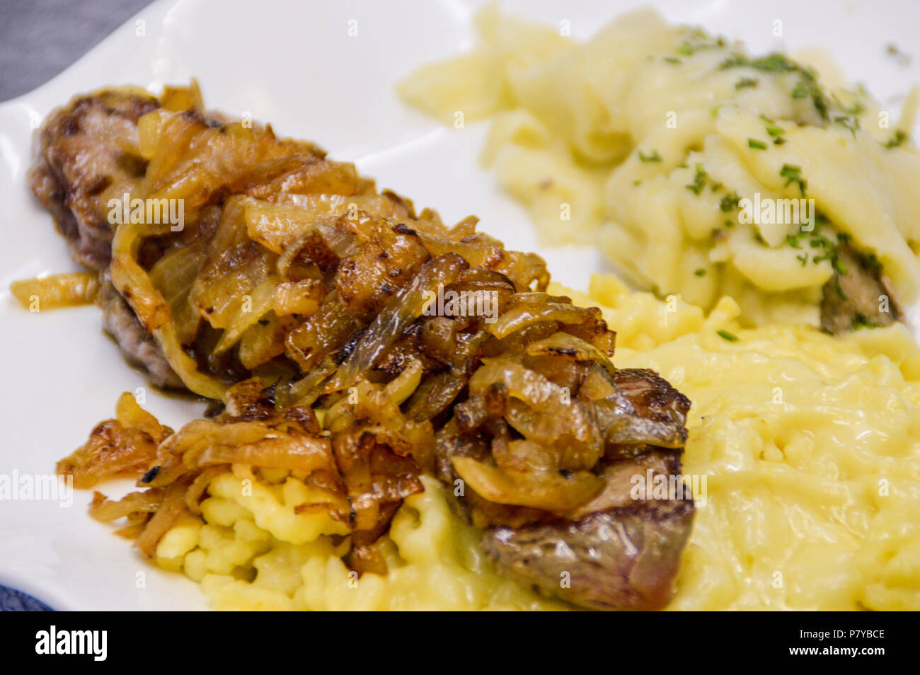 German food. Spätzle, beef steak and pork medallion with saukraut Stock ...