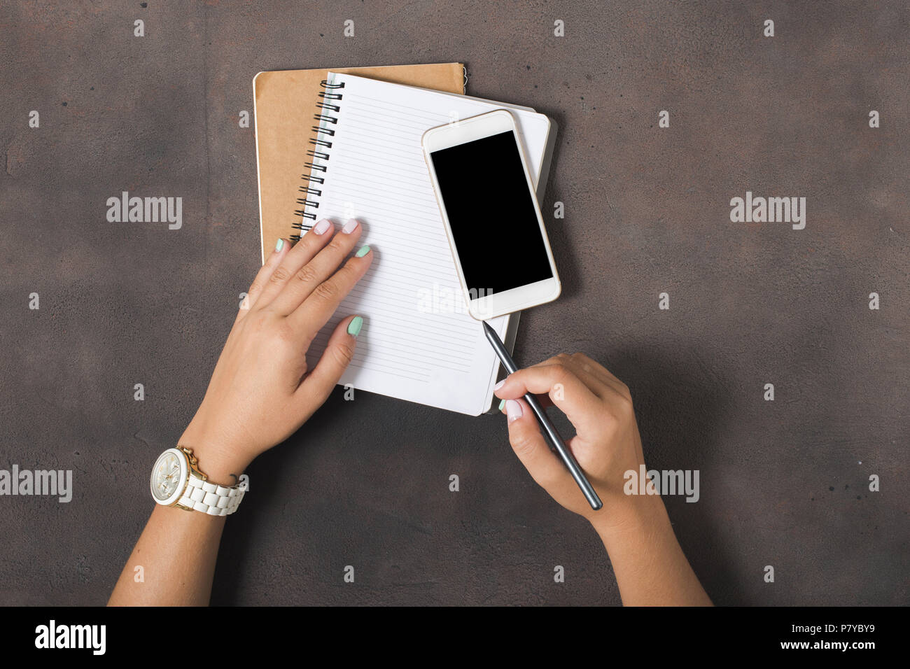 Women write in a notebook in the workplace. Flat lay, top view. Concept ...