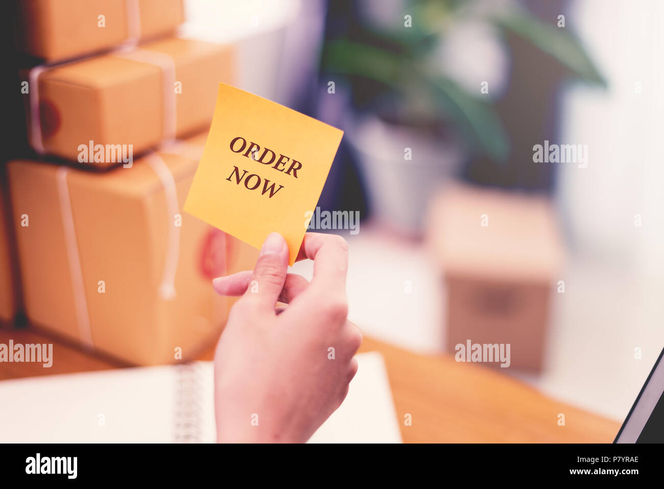 "Order Now" text on post it paper in woman hand at post office with ...