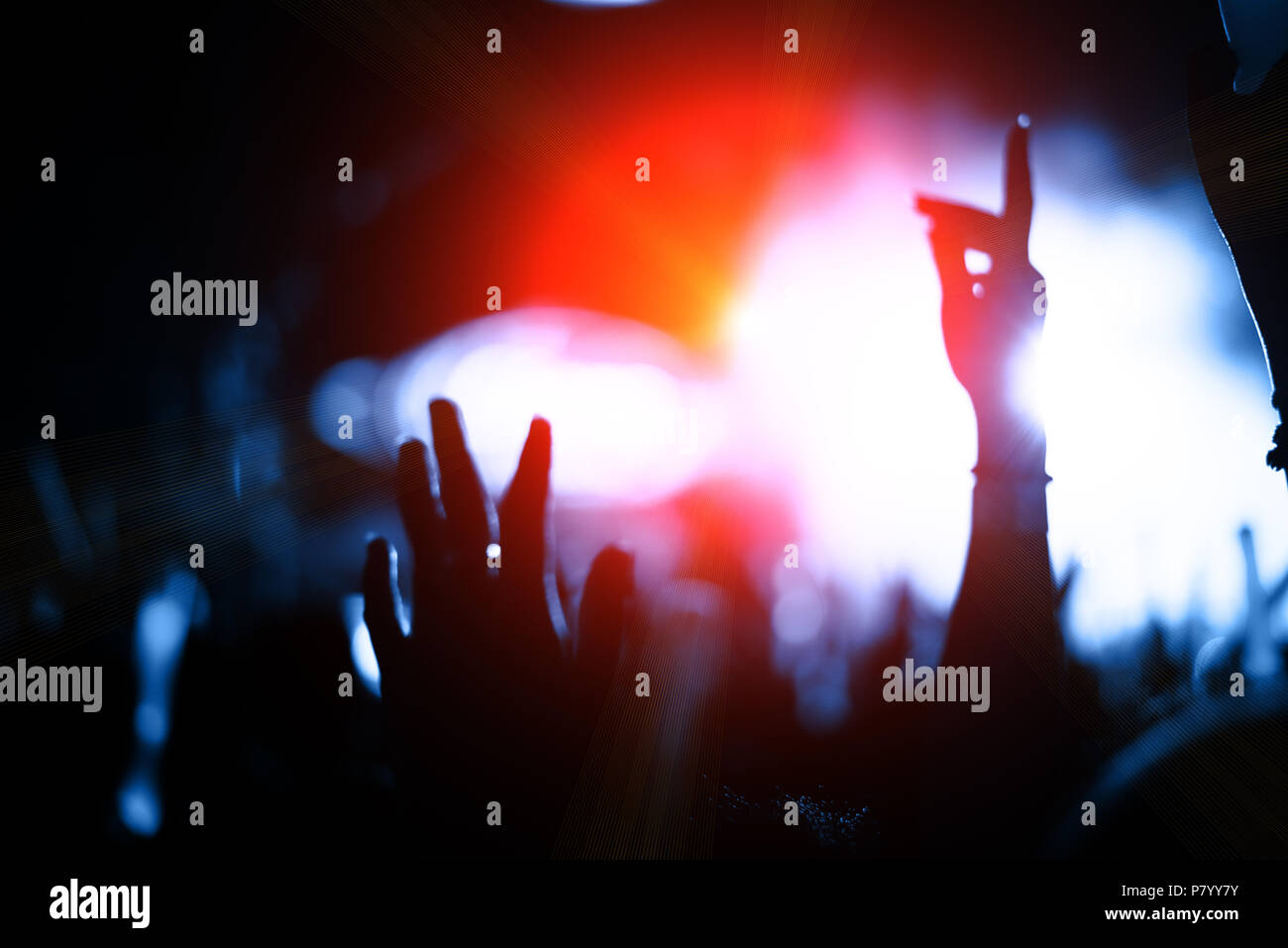 Silhouette crowd audience in concert with hands raise at music festival ...