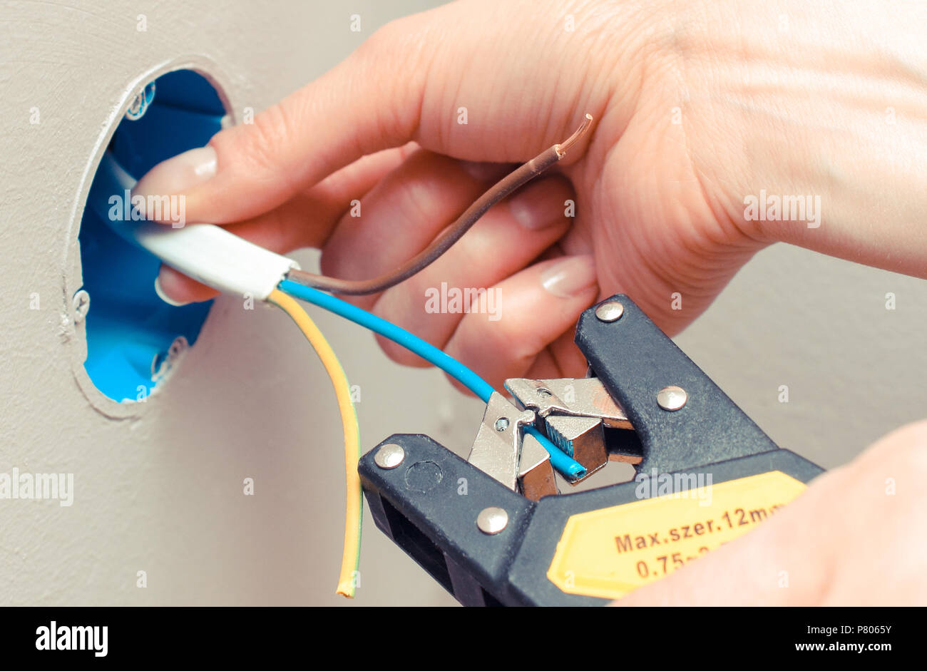 Hand of electrician insulating electric wires in electric box using ...