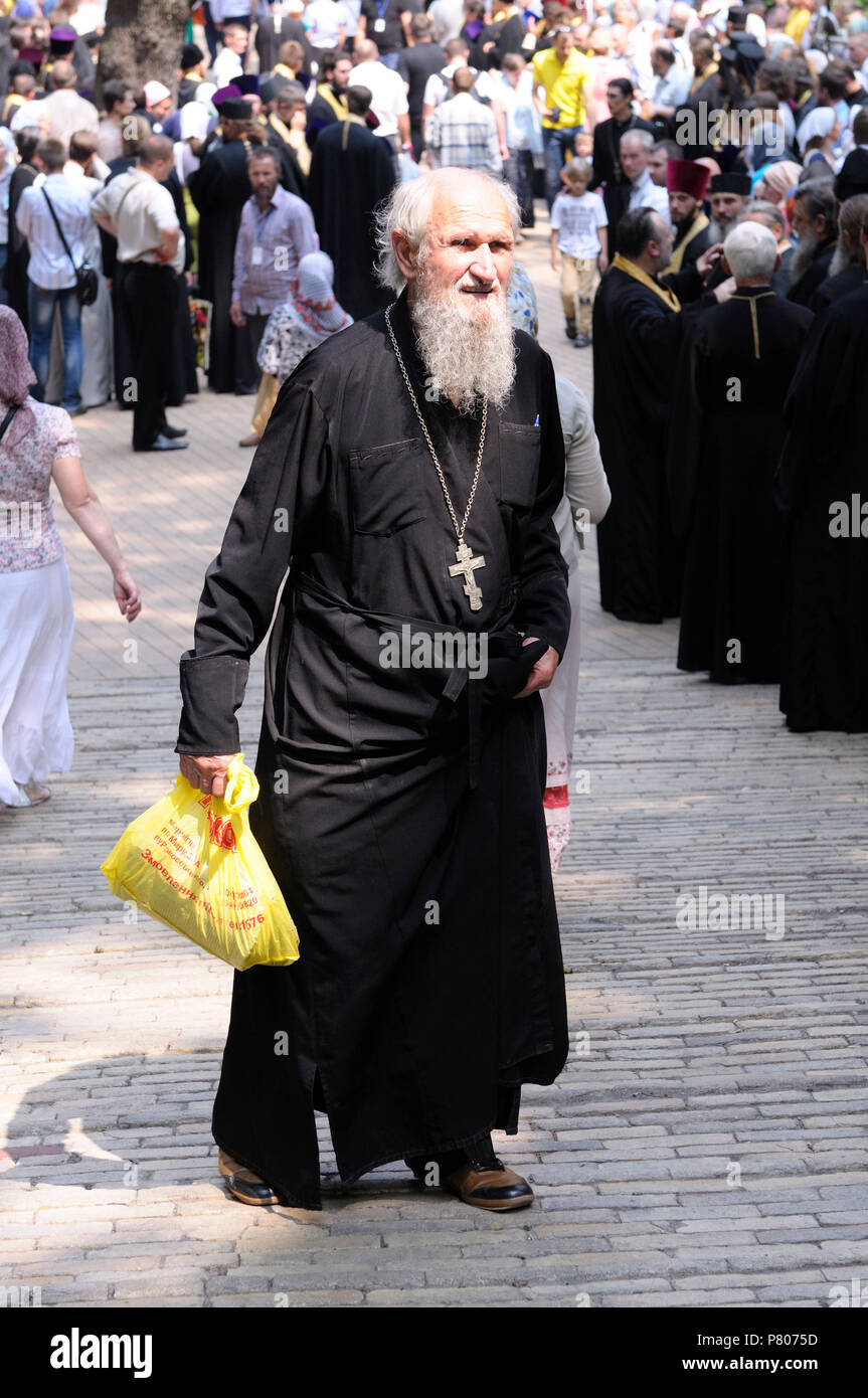 An old orthodox churchman dressed in a black cassock standing alone ...