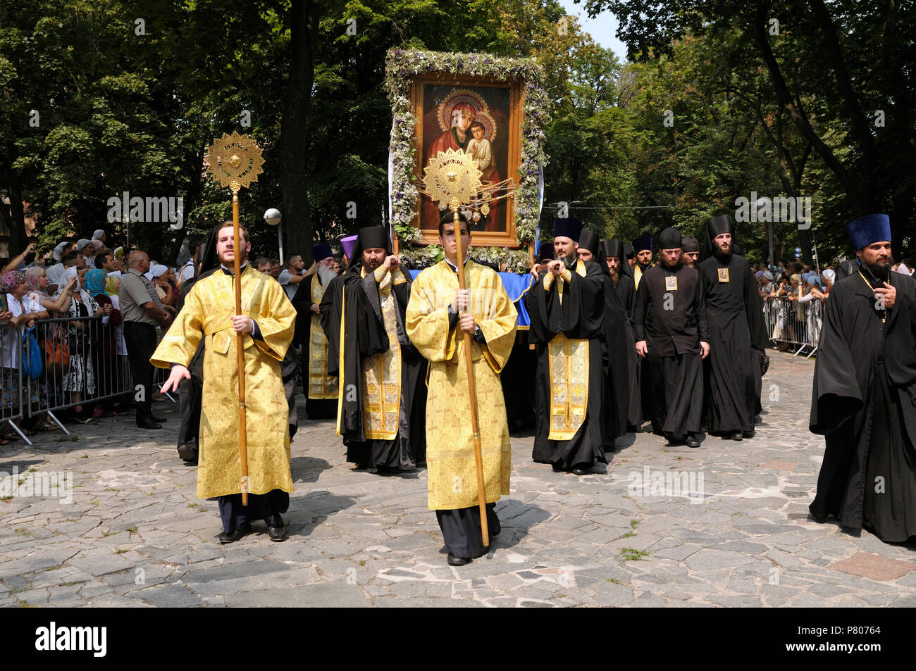 Orthodox churchmen in golden cassocks going down street, crowd of ...