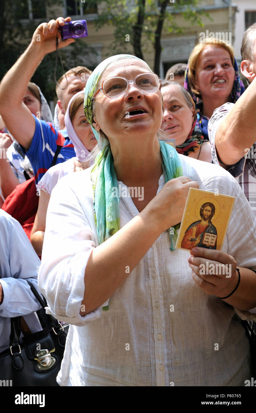 Female parishioner holding an icon and crossing herself, the Day of ...