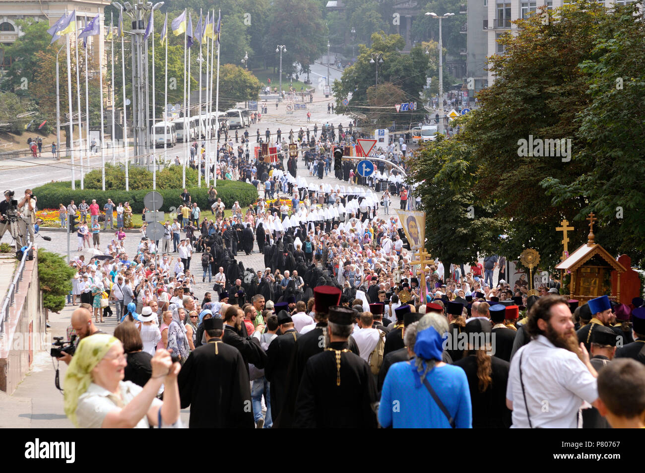 Orthodox churchmen in golden cassocks going down street, crowd of ...
