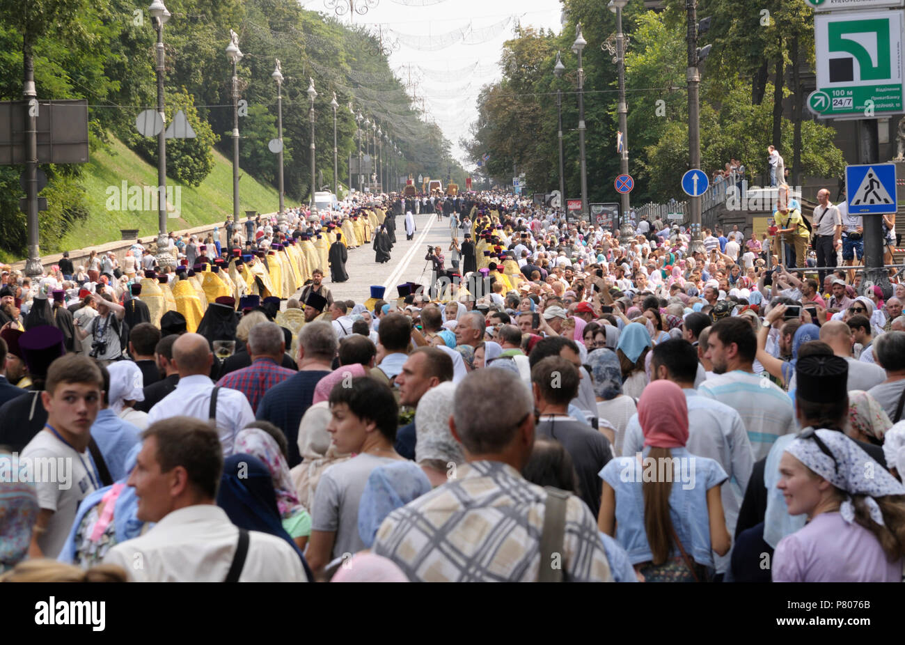 Orthodox churchmen in golden cassocks going down street, crowd of ...