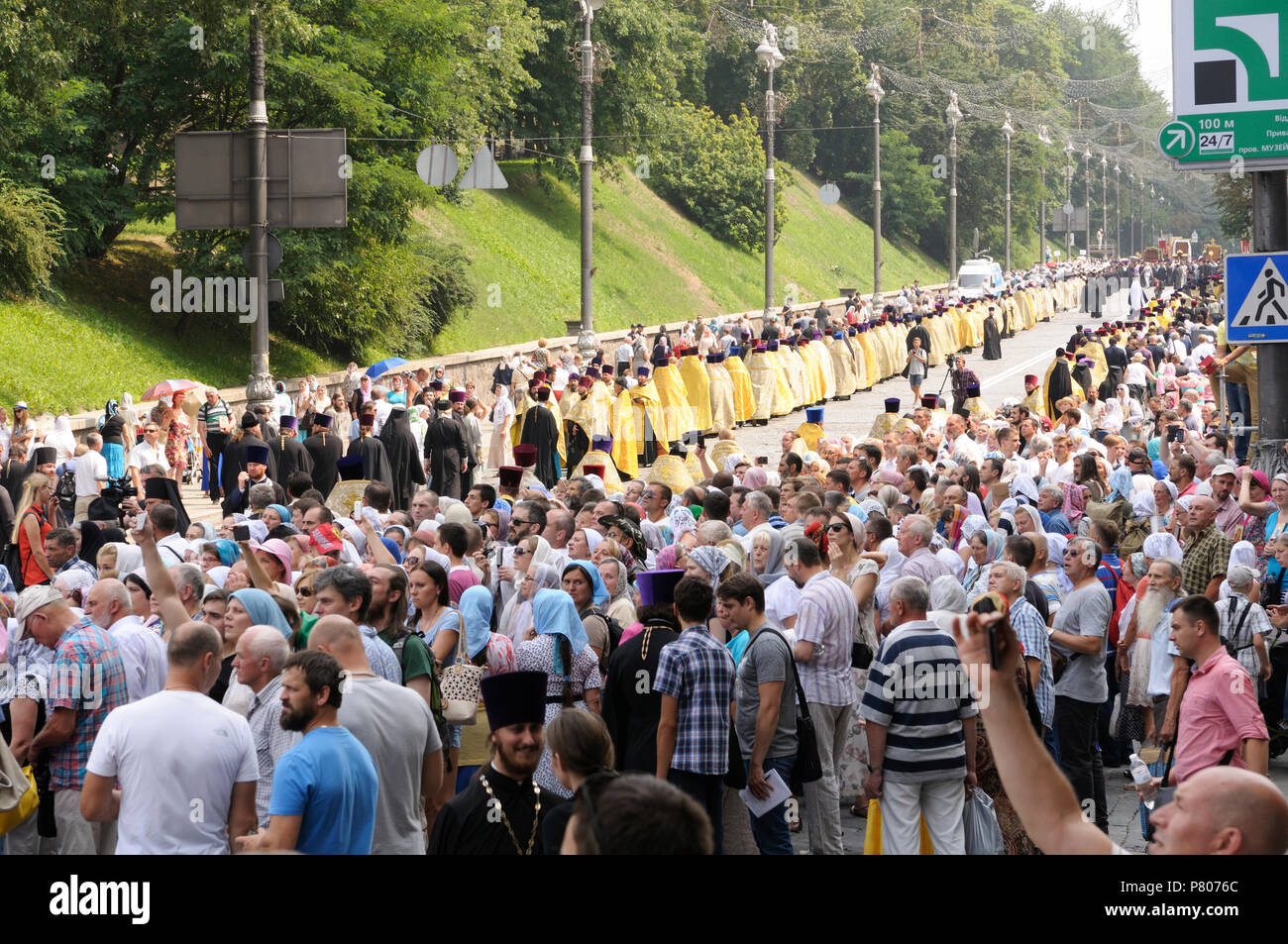 Orthodox churchmen in golden cassocks going down street, crowd of ...