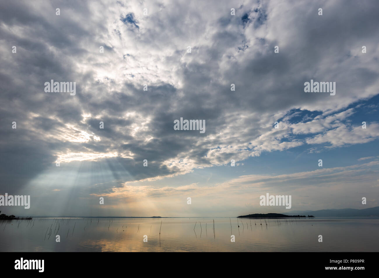 Spectacular view of a lake, with clouds, sky and sun rays reflecting on ...