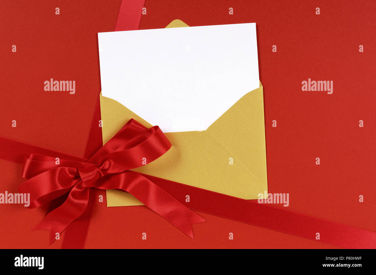 Red gift background with gold envelope and blank invitation or ...