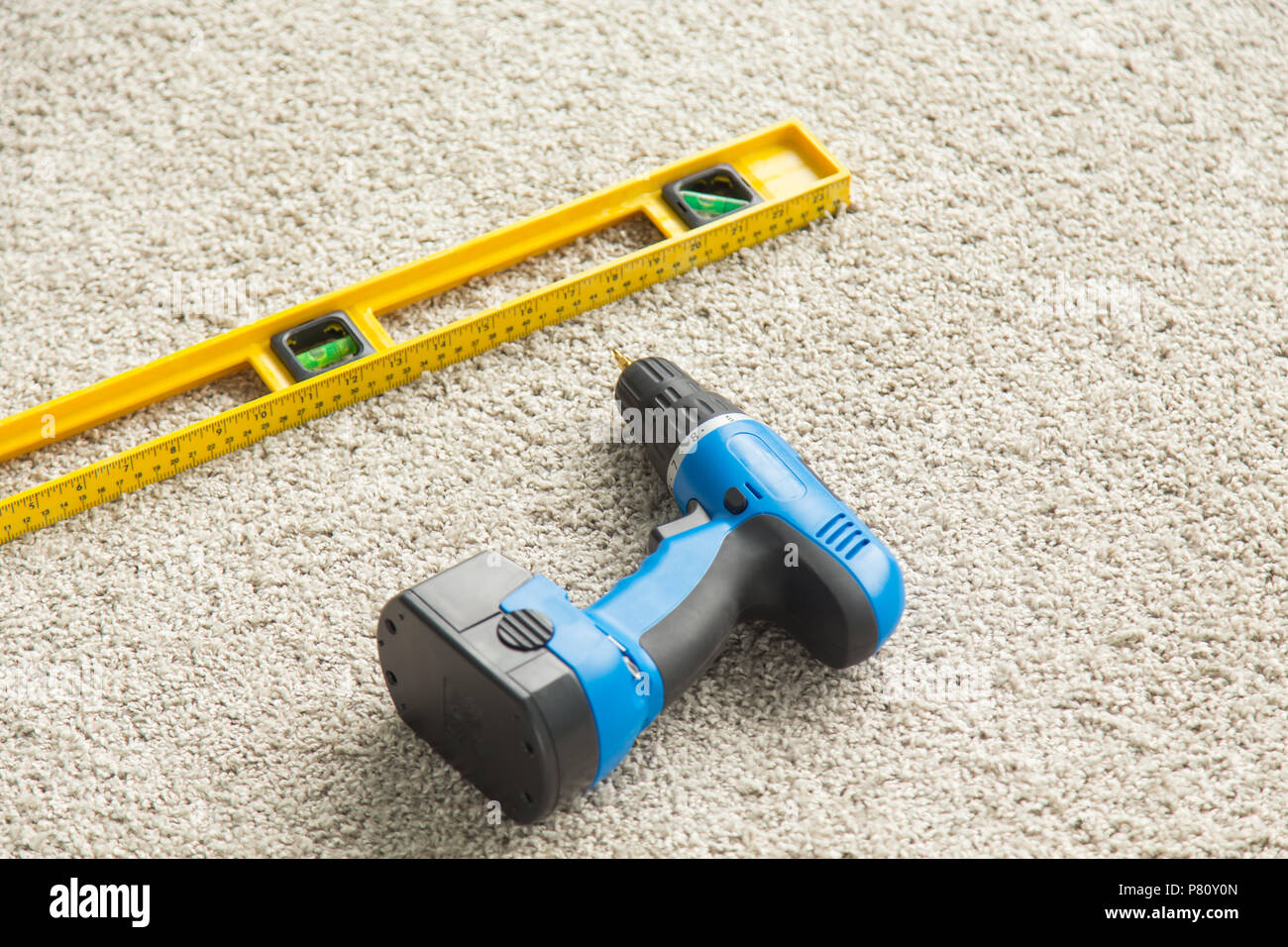Builders level and drill on the floor, top view Stock Photo - Alamy