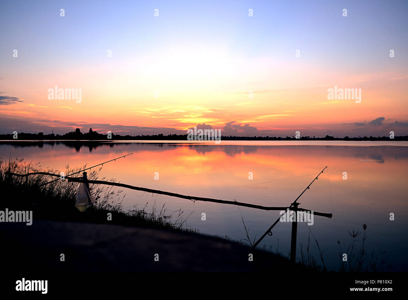 Sunset at the river with Colorful sky and fishing Stock Photo - Alamy