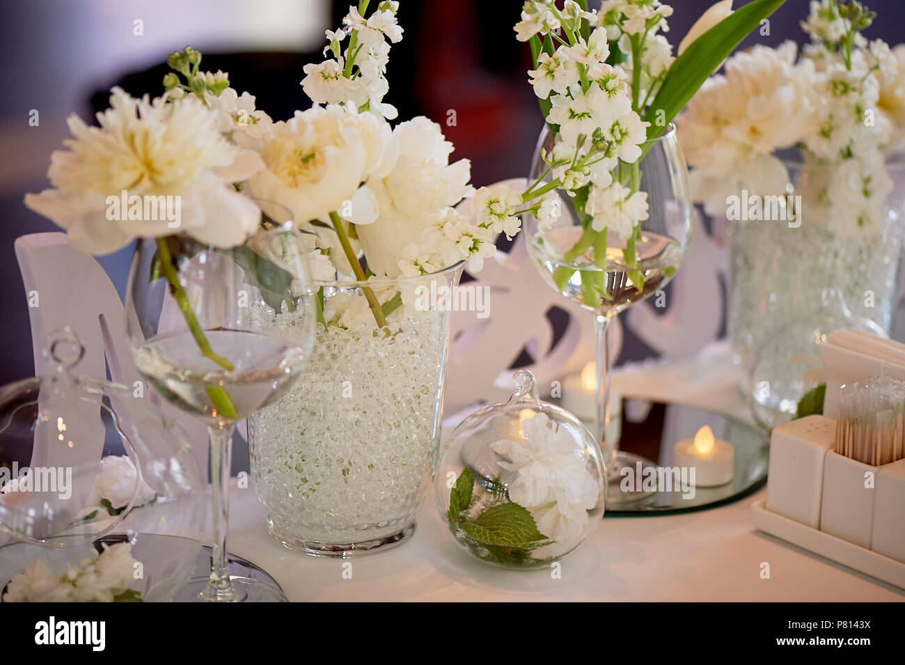 Classic table setting. White tablecloth. Vase with hydrogel and white ...
