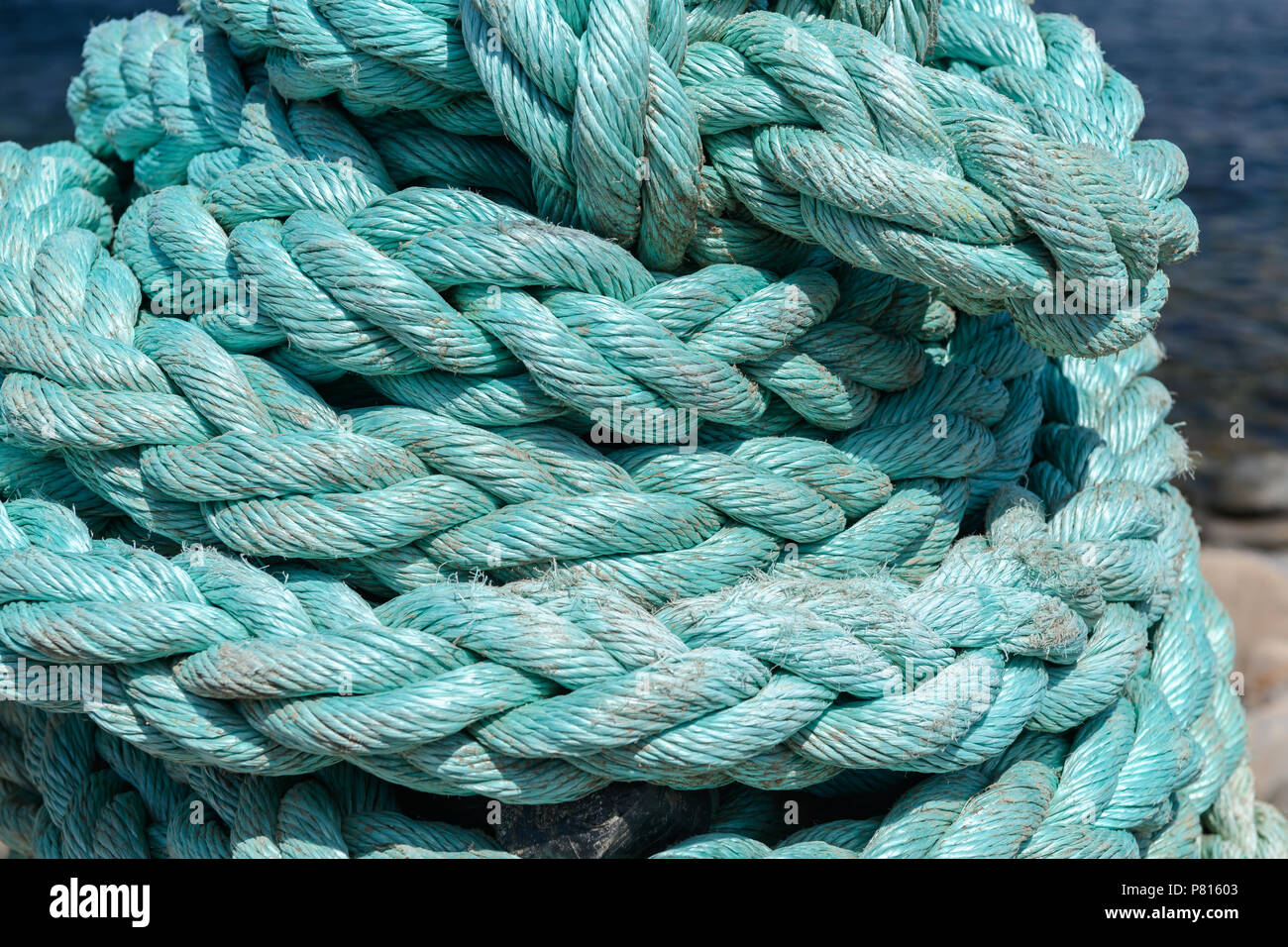 Blue rope coiled on a jetty Stock Photo - Alamy