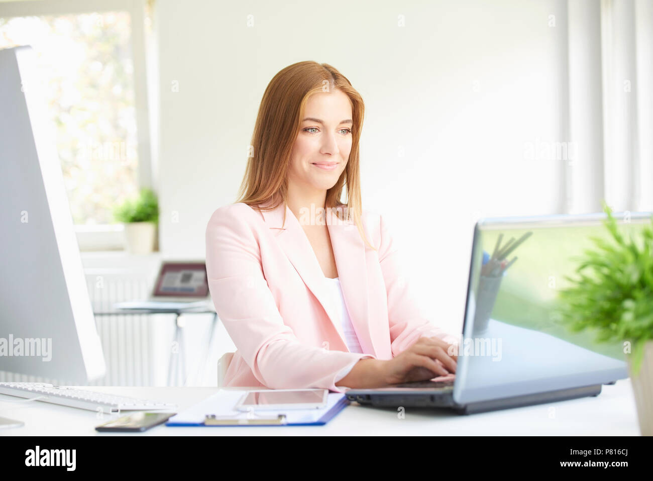 Shot of a beautiful young sales manager businesswoman working on ...