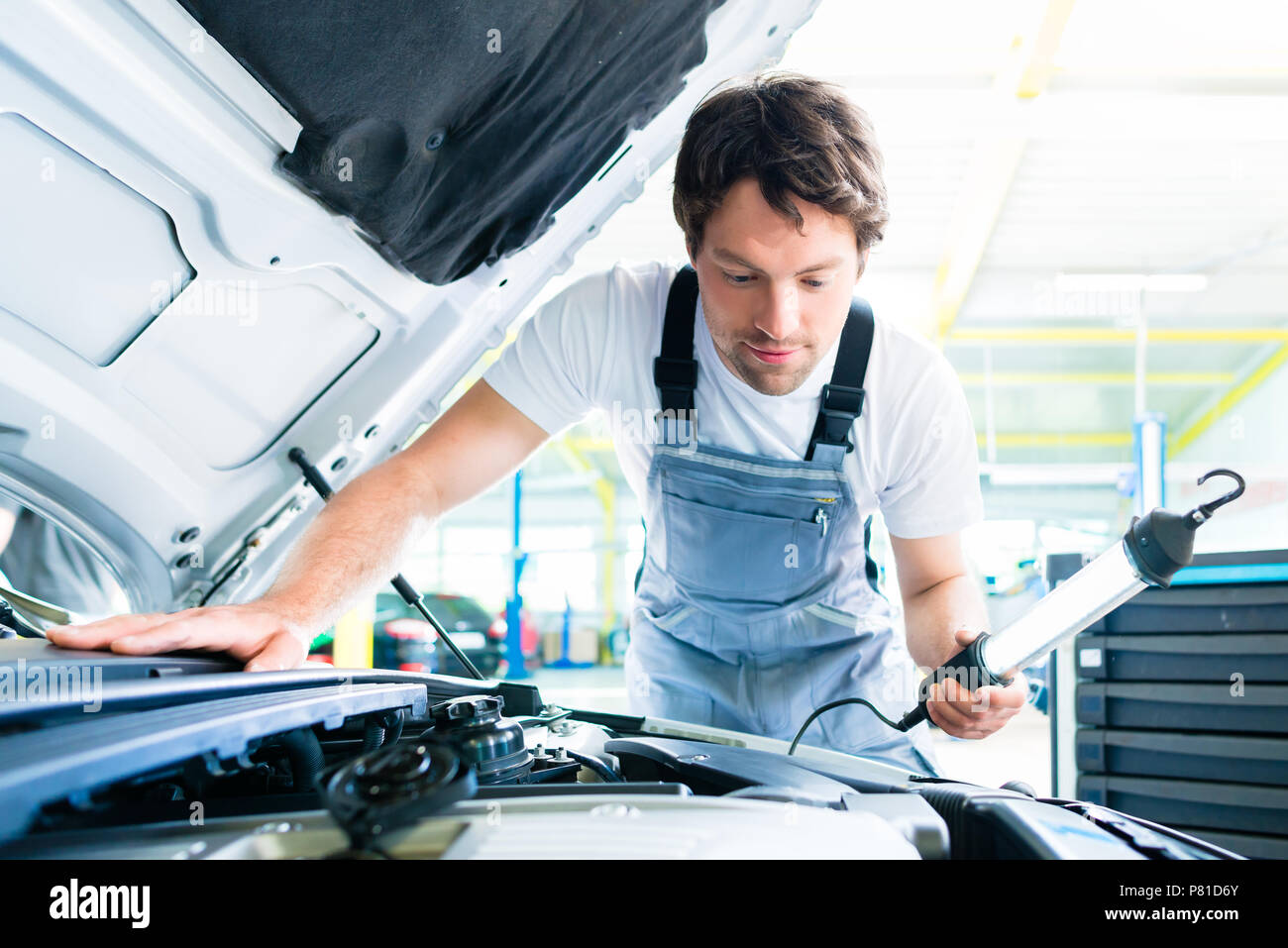 Auto mechanic working in car service workshop Stock Photo - Alamy