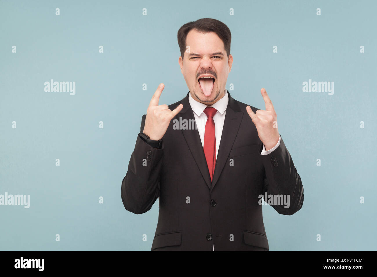 Emotional businessman showing rock sign. indoor studio shot. isolated ...