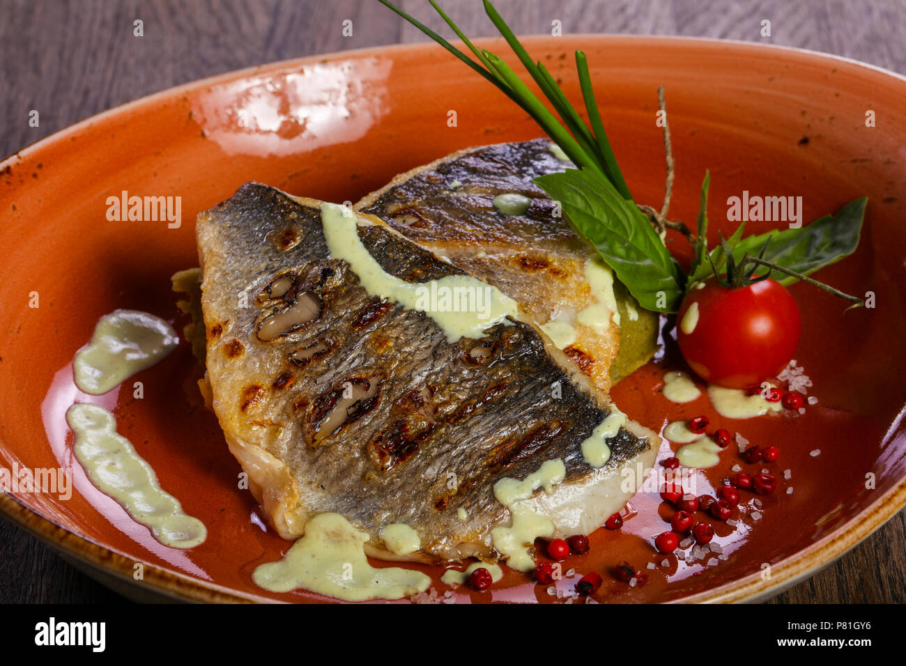 Grilled dorada fillet served tomato and onion Stock Photo - Alamy