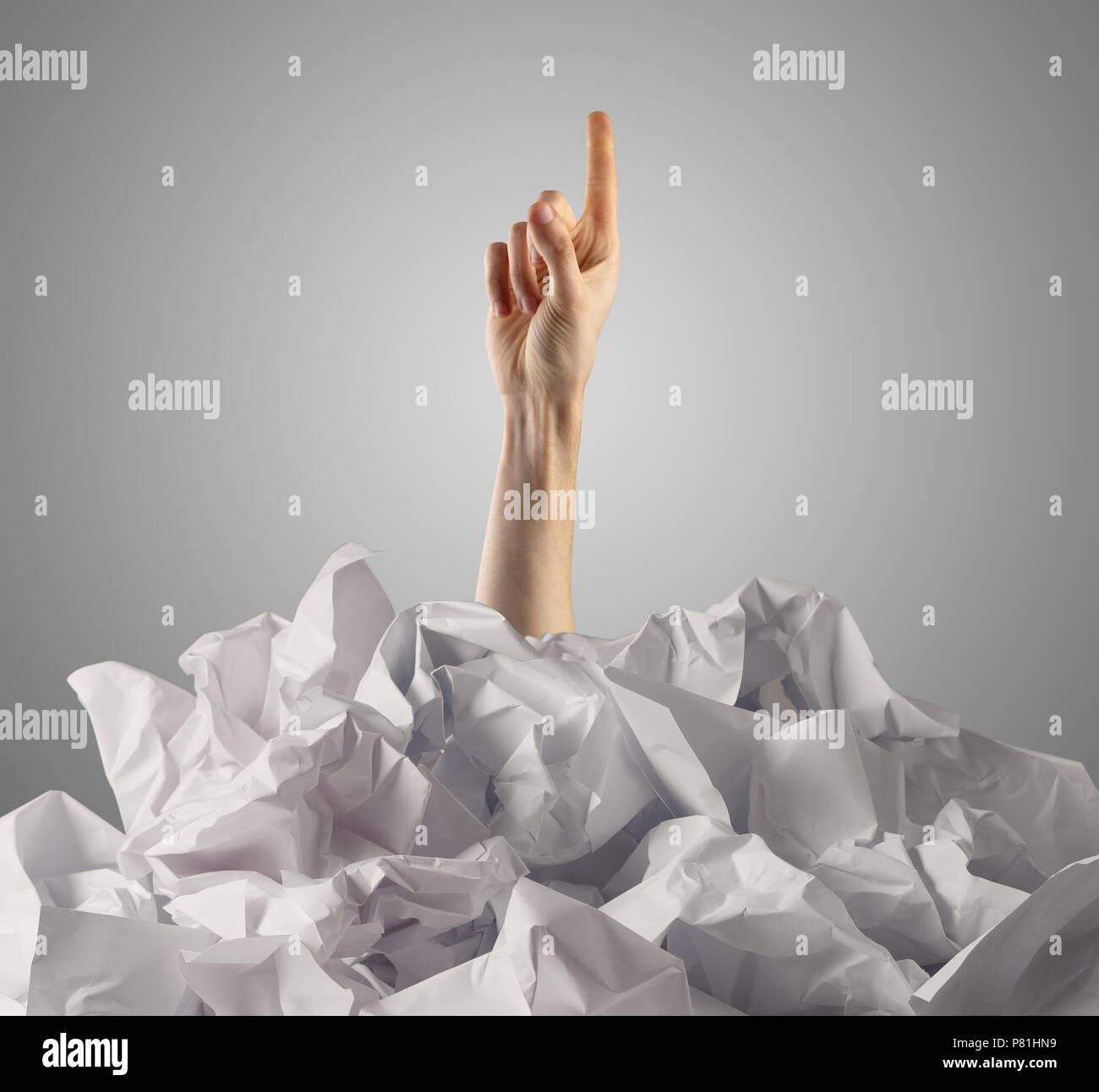Hand breaking out from pile of paper Stock Photo - Alamy