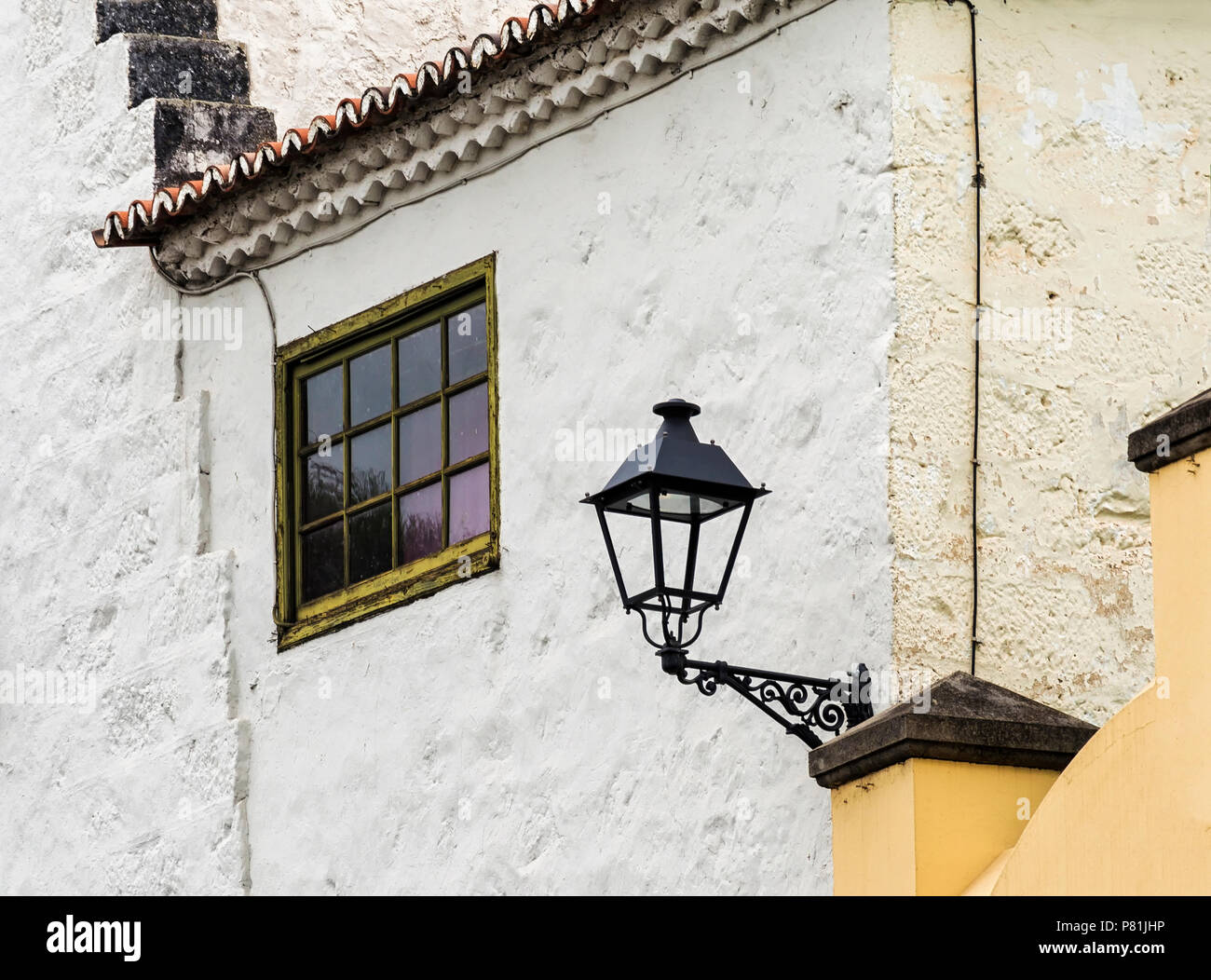 A frame of an old street lamp is attached to the wall of the building ...