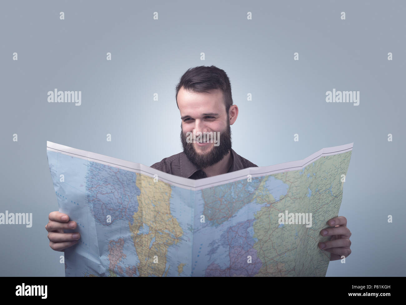 Handsome young man holding map Stock Photo - Alamy