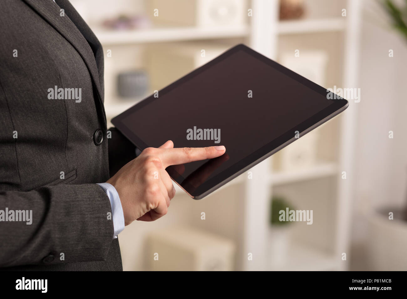 Business woman below chest using tablet in a homey environment Stock ...
