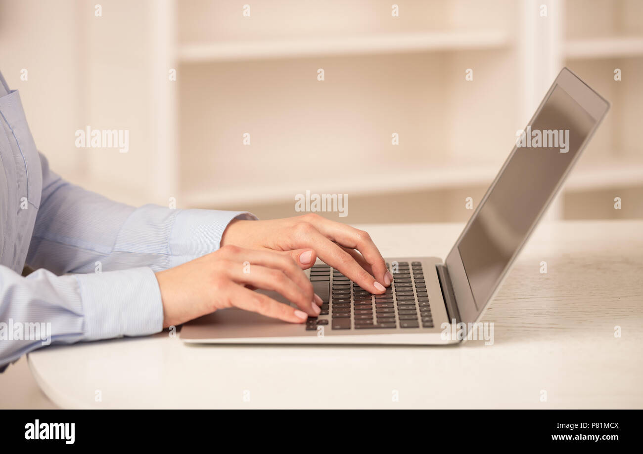 Business woman below chest working on her laptop in a cozy environment ...