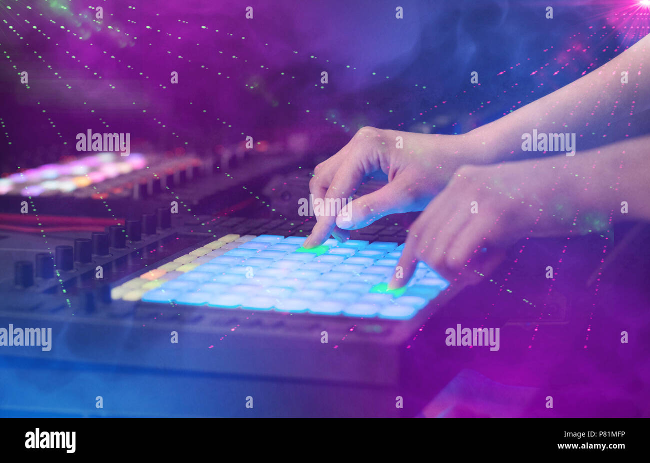 Hand mixing music on midi controller with party club colors around ...