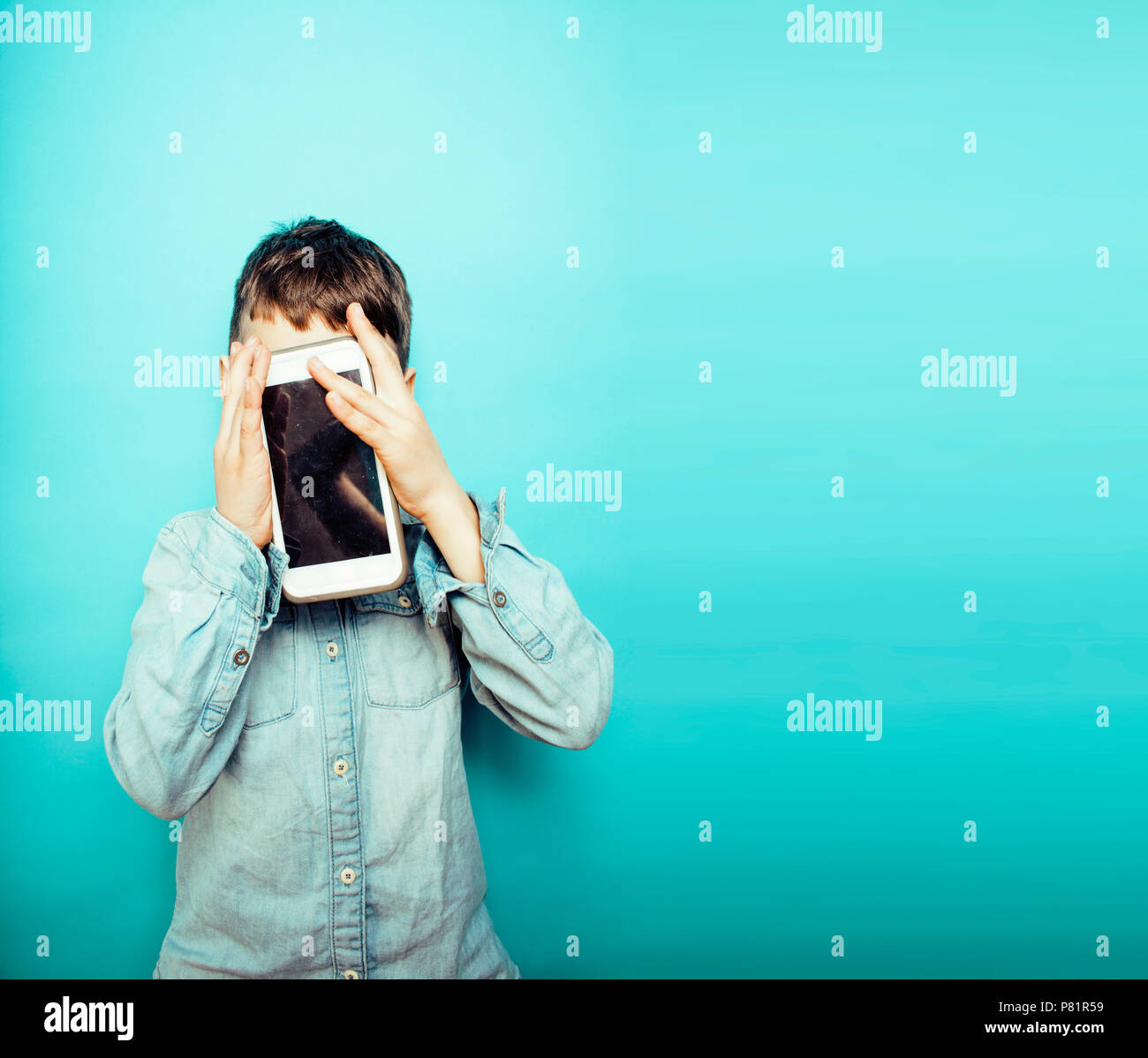 little cute boy posing emotional on blue background with smartph Stock ...