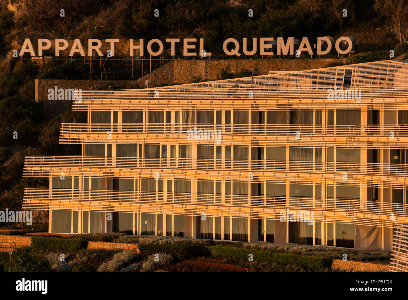 The orange light of dawn over the hotel of Quemado beach in Al Hoceima ...