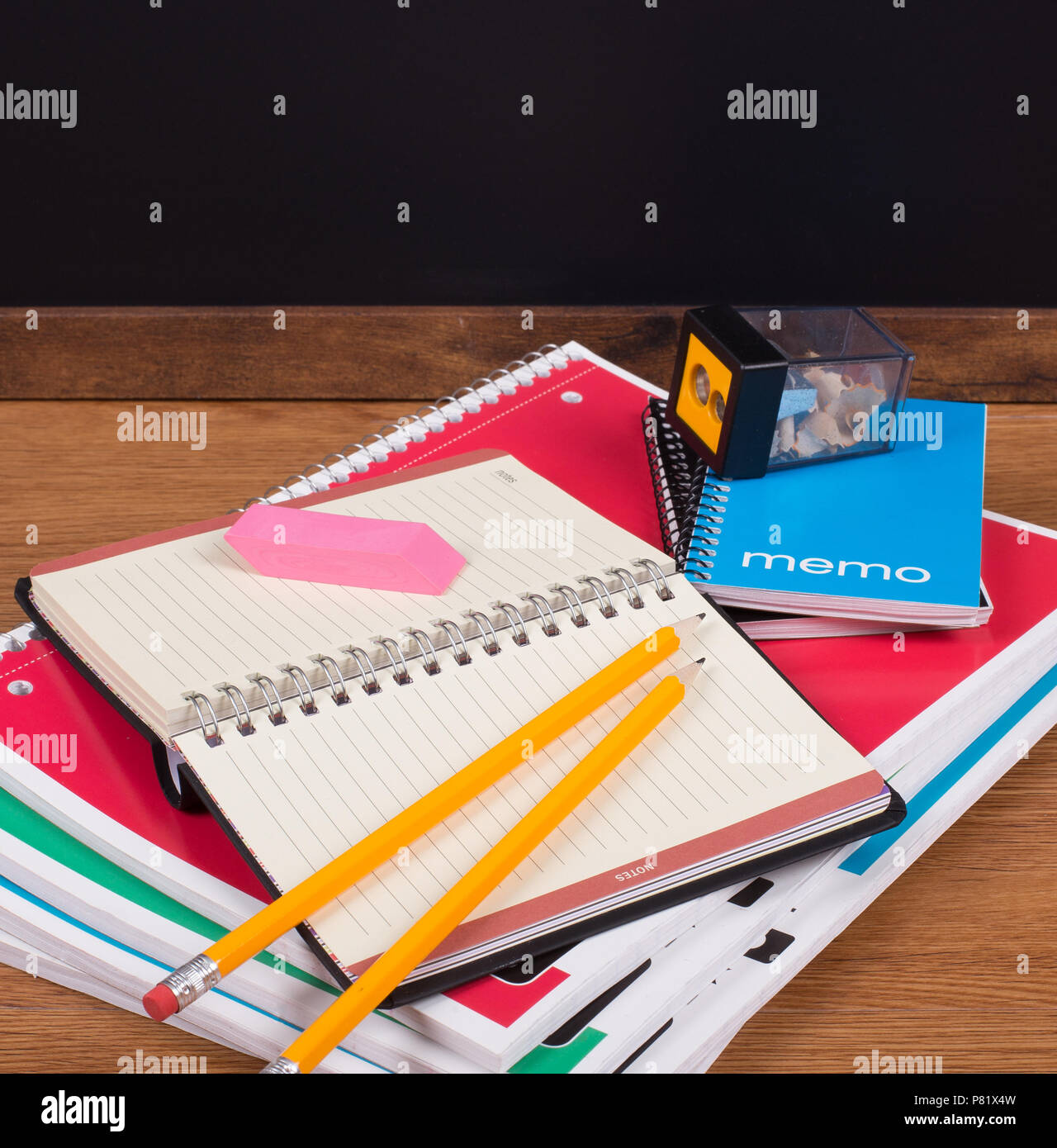 Stack of school notebooks on a desktop with a blank blackboard in ...