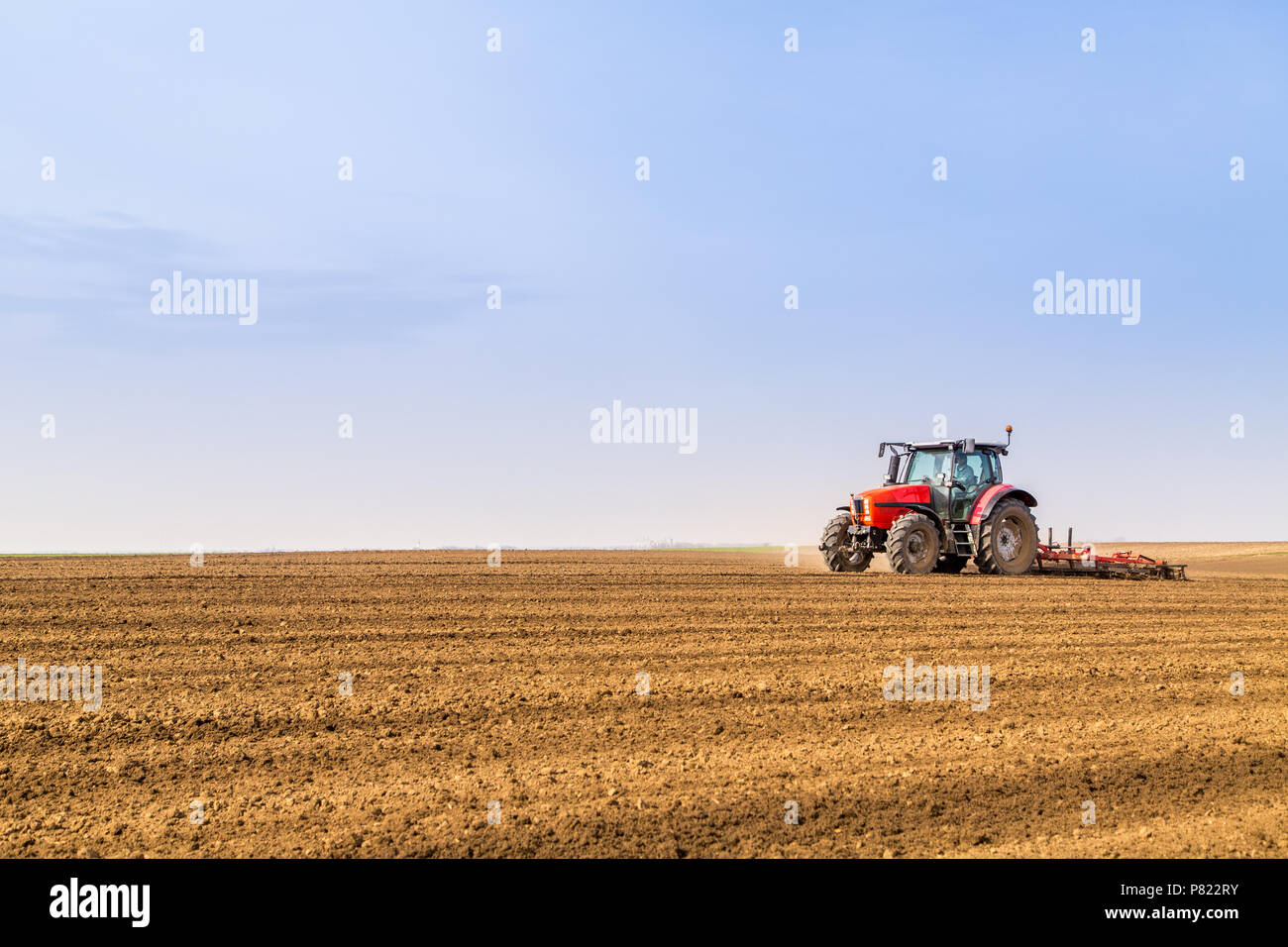 Farmer in tractor preparing land with seedbed cultivator Stock Photo ...