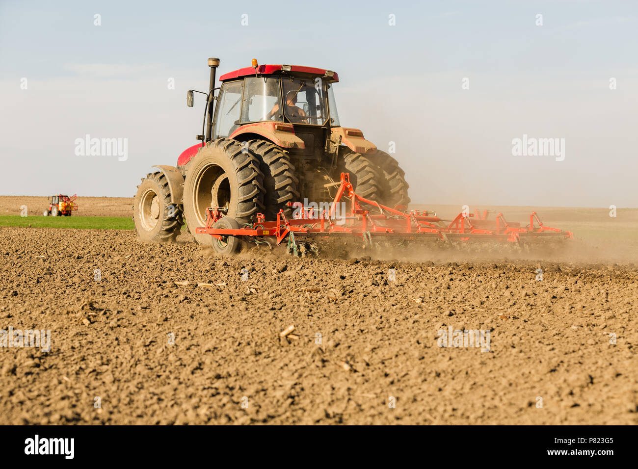 Farmer in tractor preparing land with seedbed cultivator Stock Photo ...