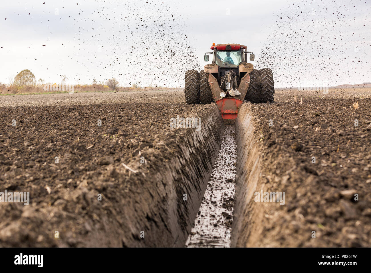 Tractor with double wheeled ditcher digging drainage canal Stock Photo - Alamy