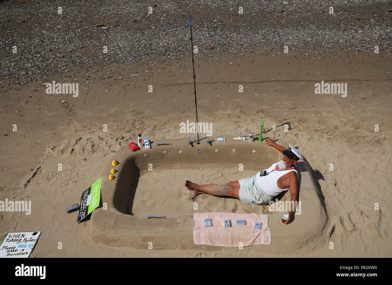 Ron, also known as "The Beach Captain", poses in his 'shower' sand ...