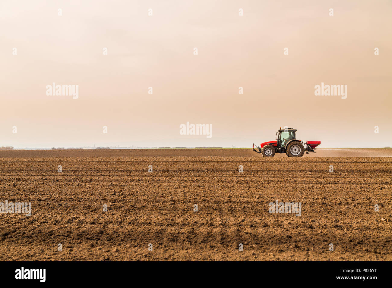 Farmer fertilizing arable land with nitrogen, phosphorus, potassium ...
