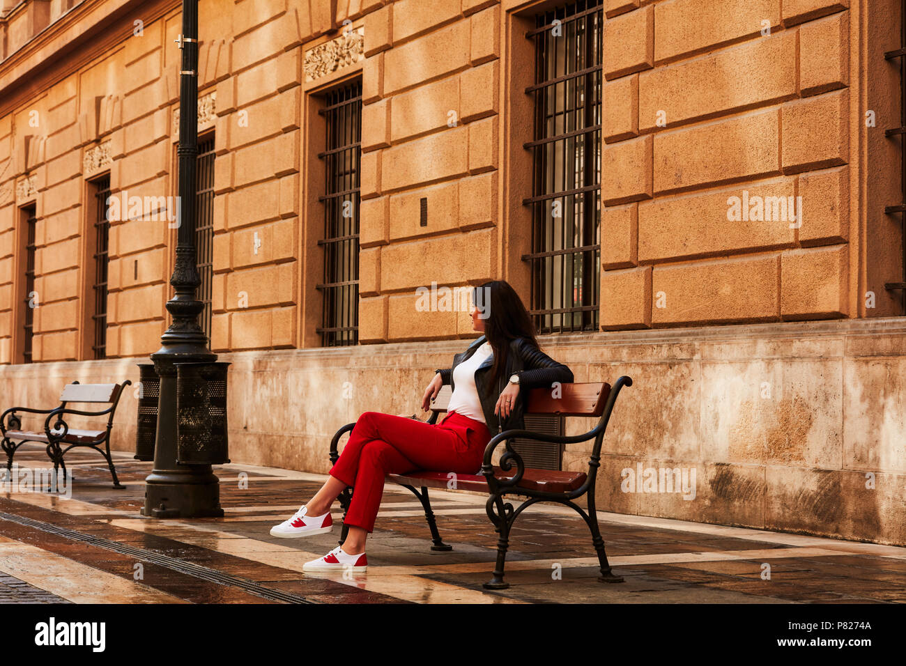 Beautiful girl sitting on the bench on the street Stock Photo - Alamy