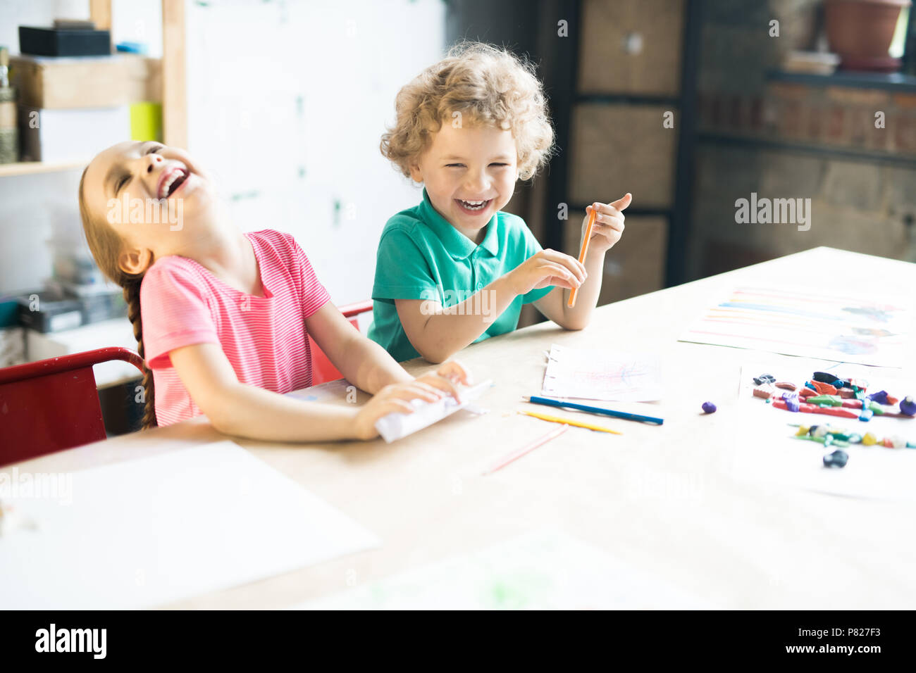 Laughing Kids Drawing at Table Stock Photo - Alamy